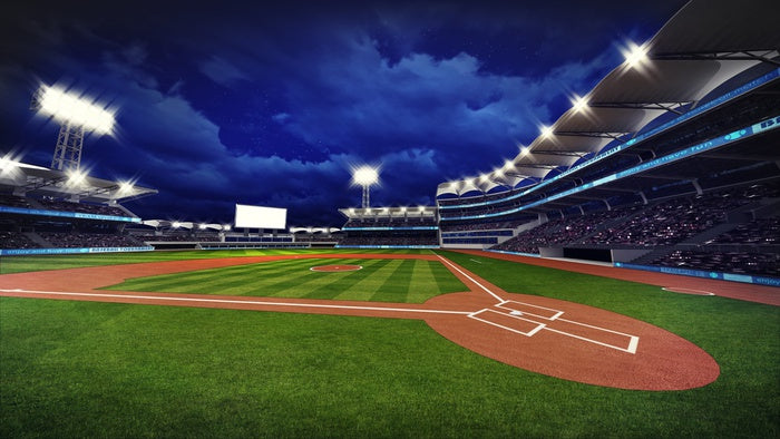 Illuminated Modern Baseball Stadium With Spectators And Green Grass Wa
